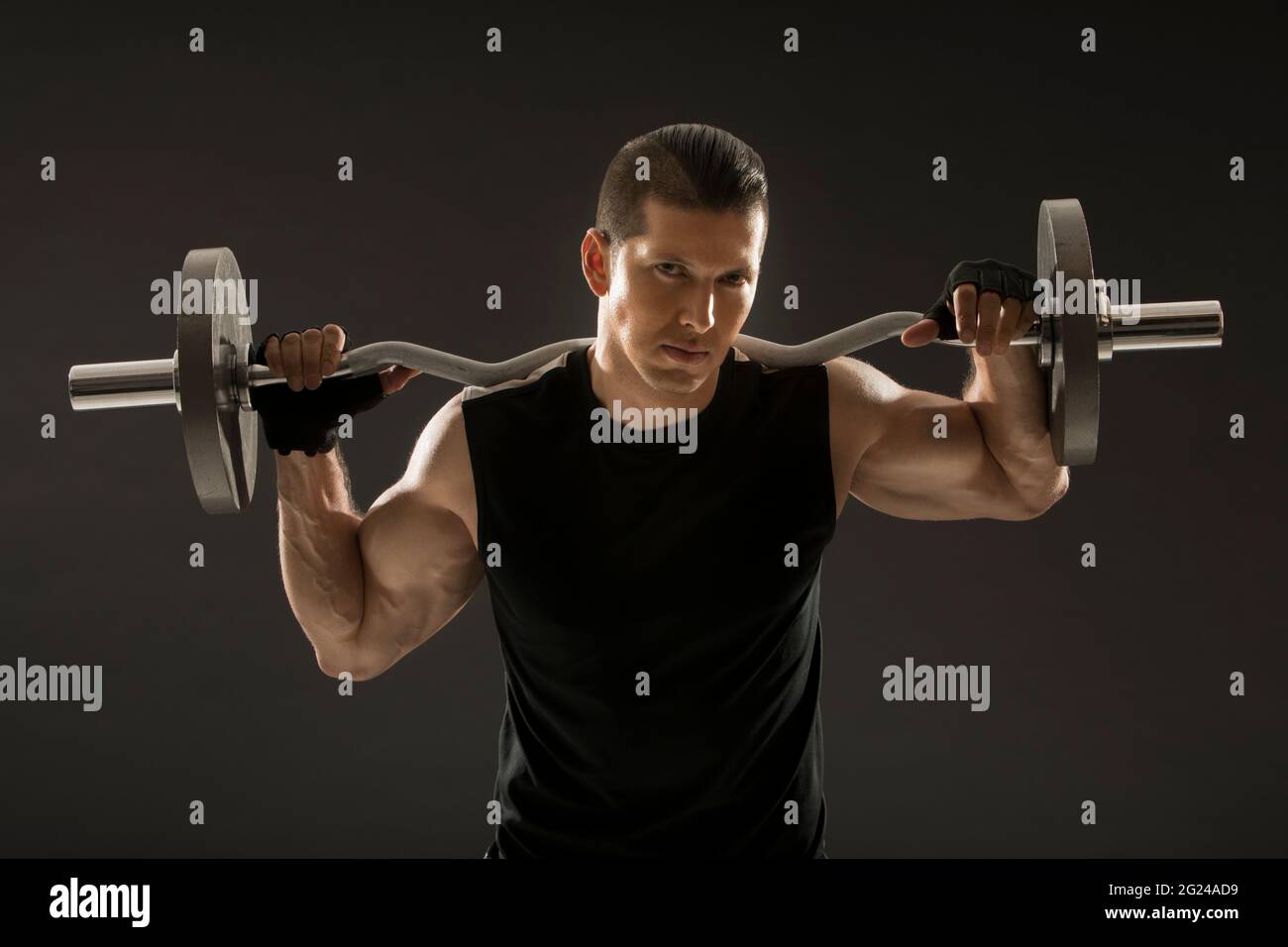 Muscular man training with barbell Stock Photo - Alamy