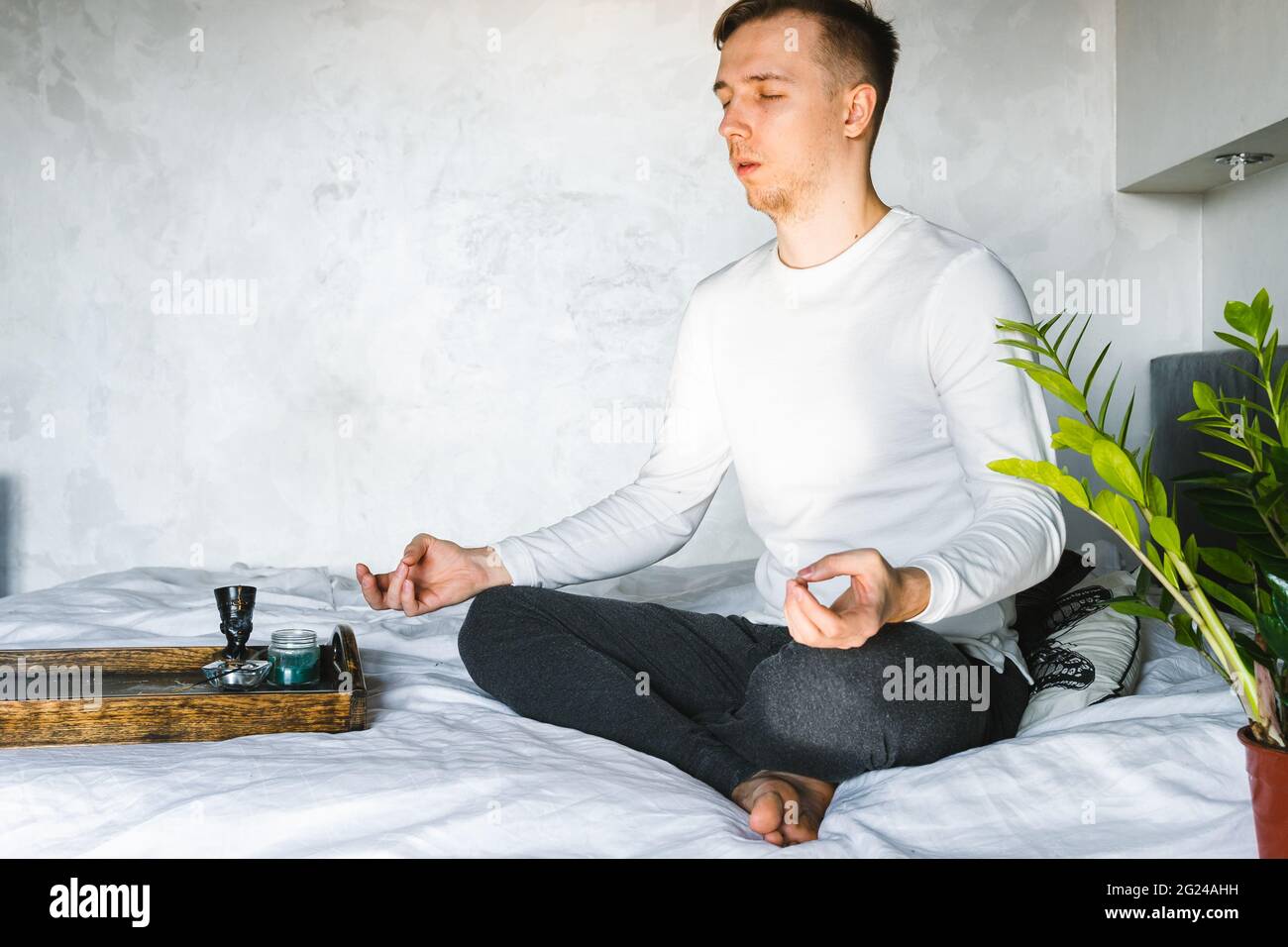 Man Sitting On Bed At Home Meditating after waking up in morning ...