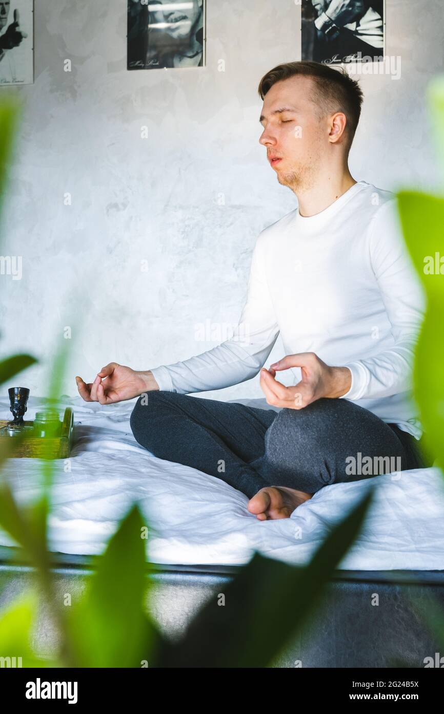 Man Sitting On Bed At Home Meditating after waking up in morning ...