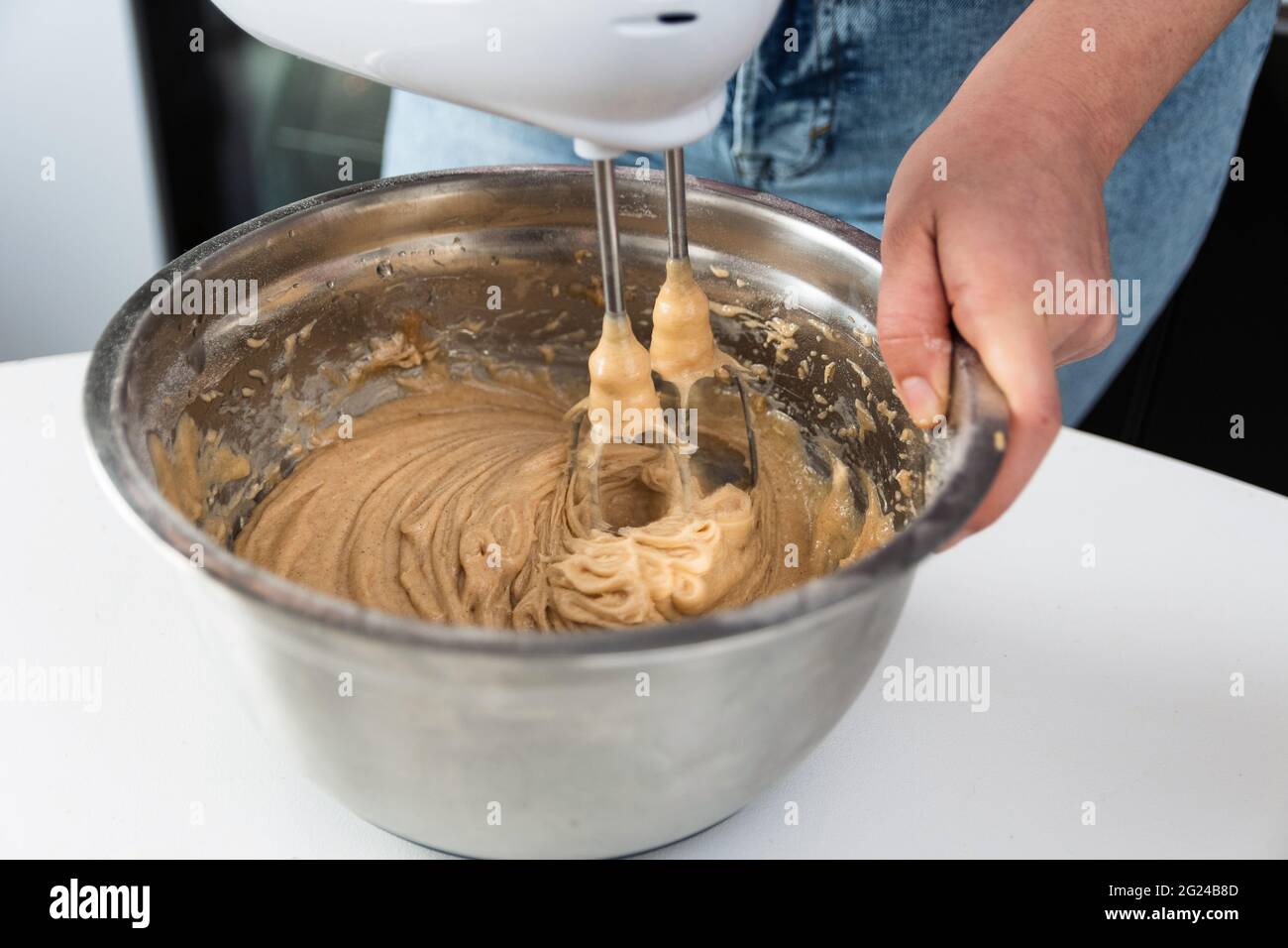Close-up cropped image of woman mixing cake ingredients with kitchen ...