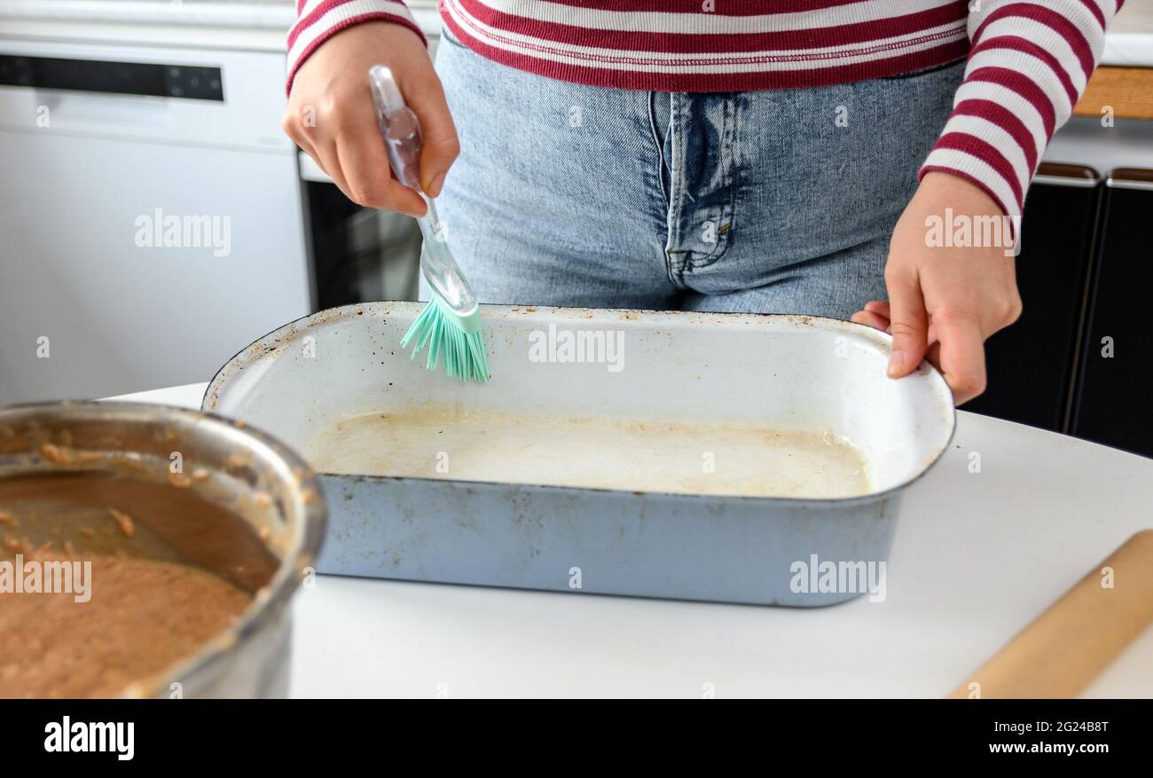 Close-up image of woman greasing a cake pan for baking Stock Photo - Alamy