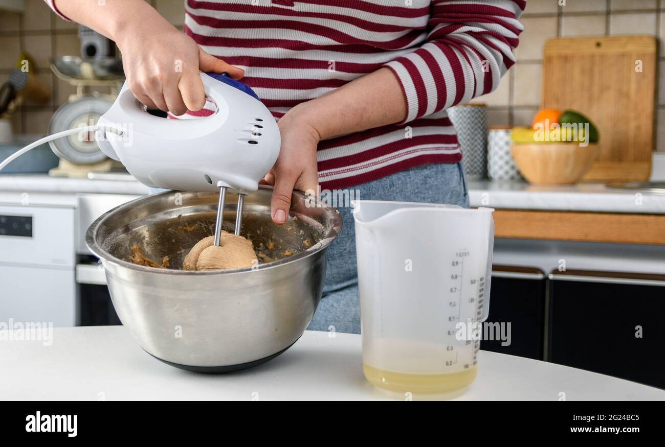 Close-up image of woman mixing ingredients in bowl while cooking and ...