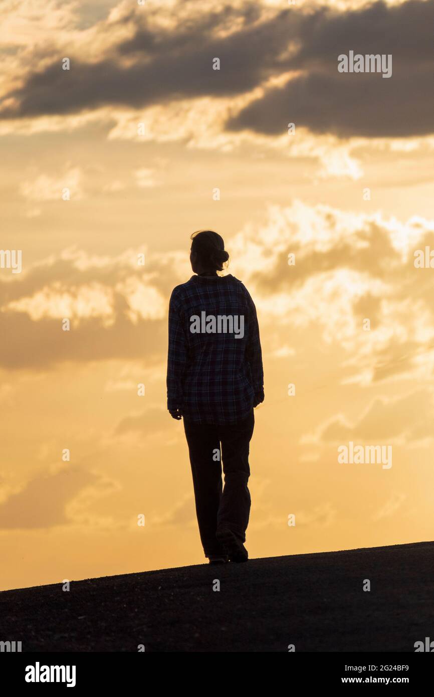 Silhouette of woman standing against sunset sky Stock Photo - Alamy