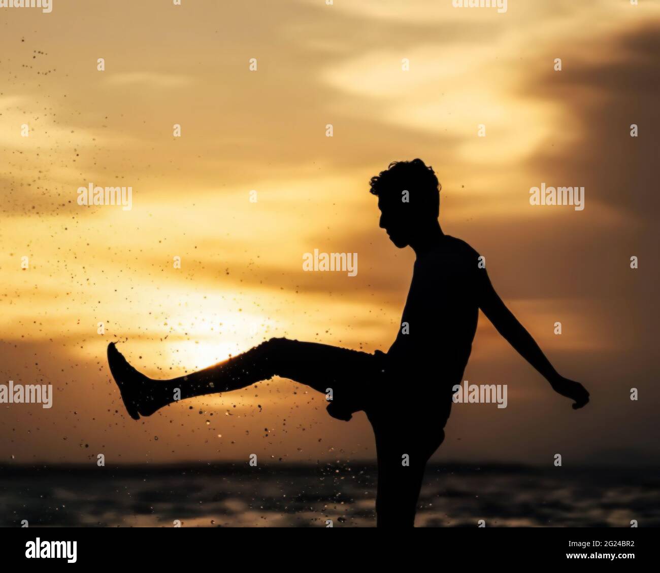 Strong man playing in beach water Stock Photo - Alamy