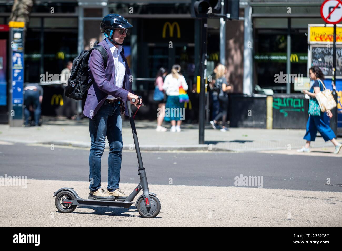 London, UK. 8 June 2021. A man rides his private electric scooter at Cambridge Circus. Currently ...
