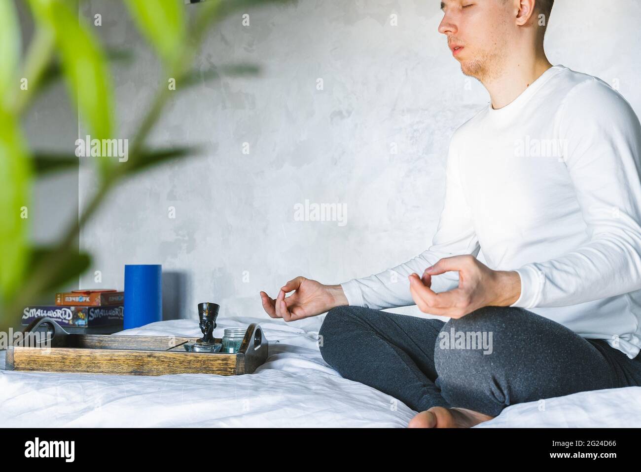 Man Sitting On Bed At Home Meditating after waking up in morning ...