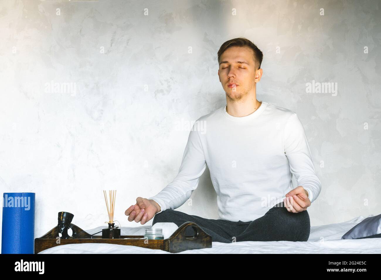 Man Sitting On Bed At Home Meditating after waking up in morning ...