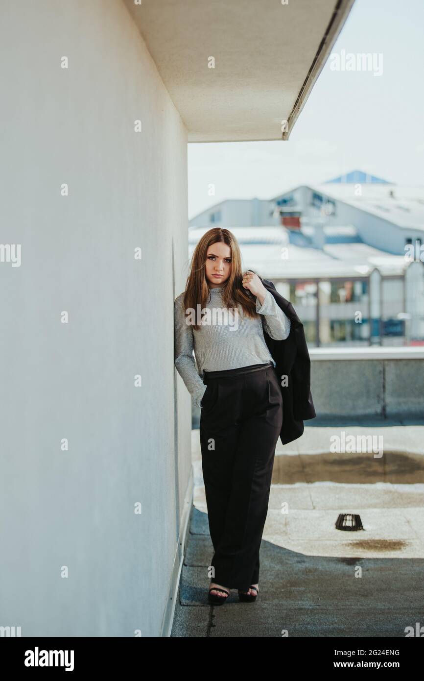 Young female with a classic outfit posing on a rooftop Stock Photo - Alamy