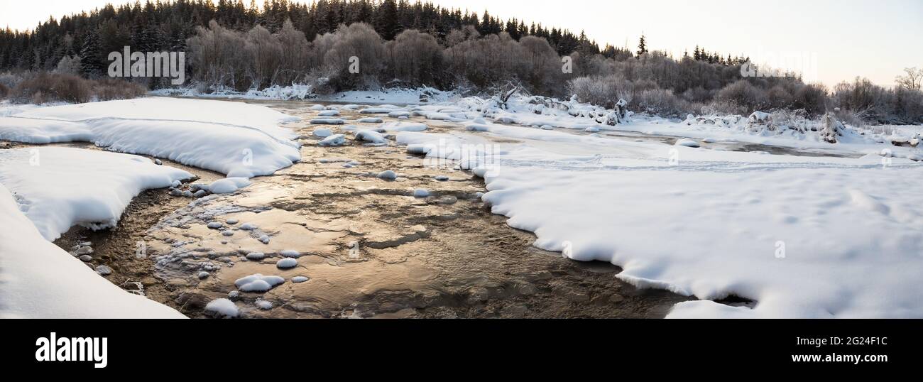 Water flowing between ice and snow in a river in winter Stock Photo - Alamy