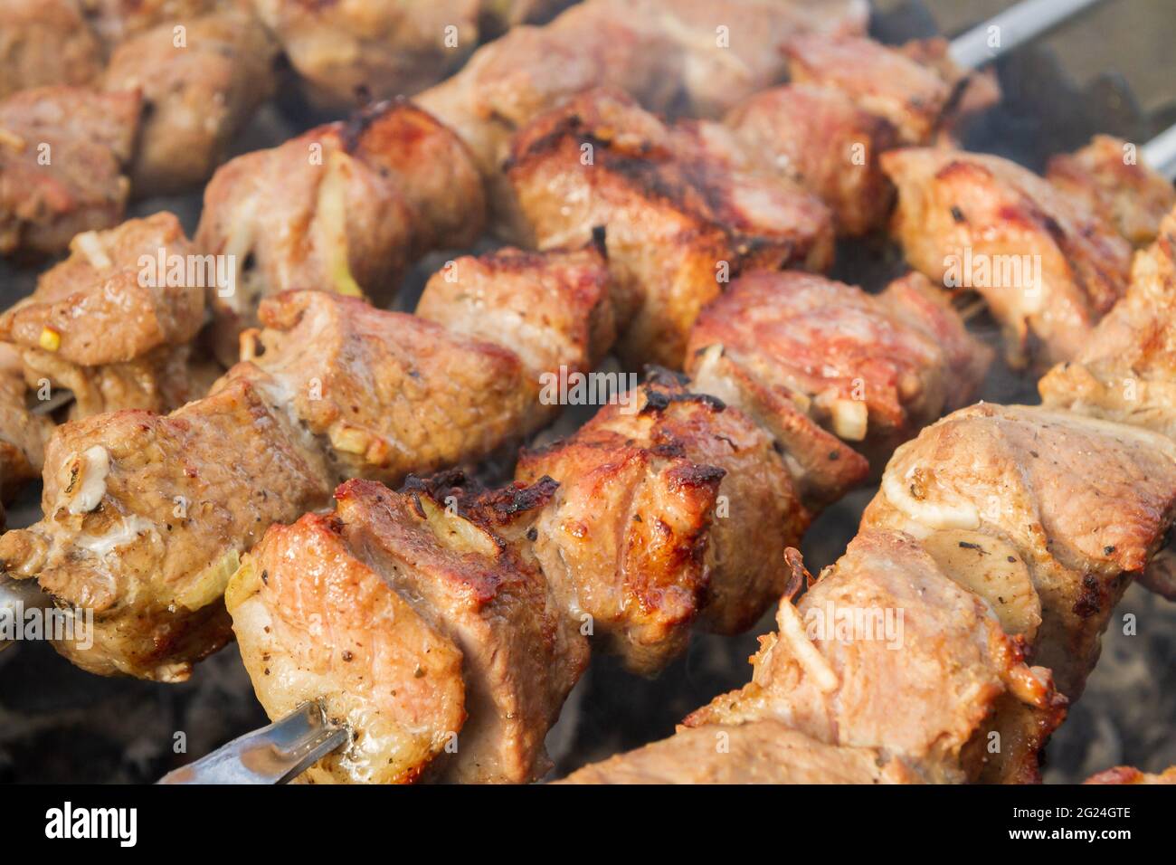 Shish Kebab made from pieces of pork is cooked on skewers on the grill ...