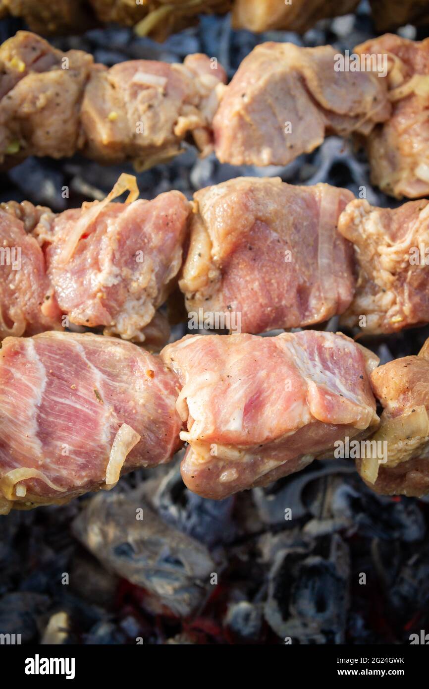 Shish Kebab made from pieces of pork is cooked on skewers on the grill ...