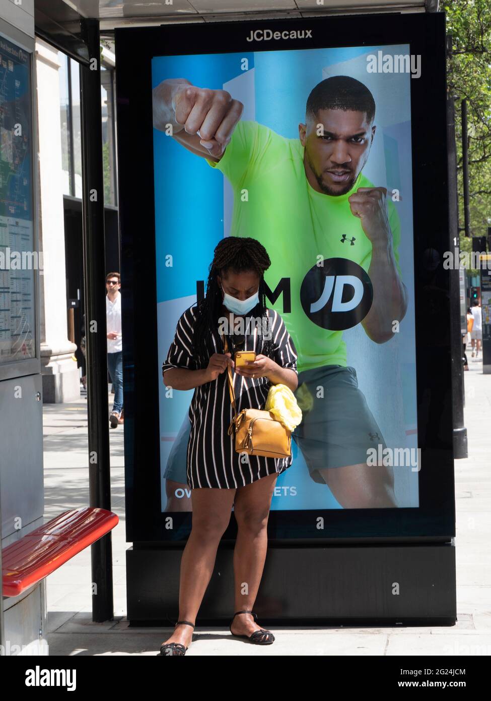 female on phone in Oxford Street stands at bus stop in front of ...