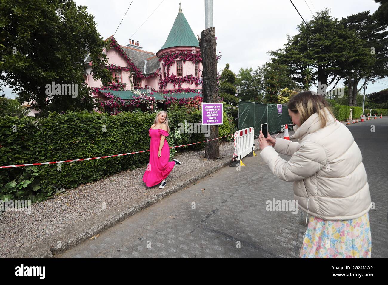 A woman poses for a photograph in front of a decorated house in the ...