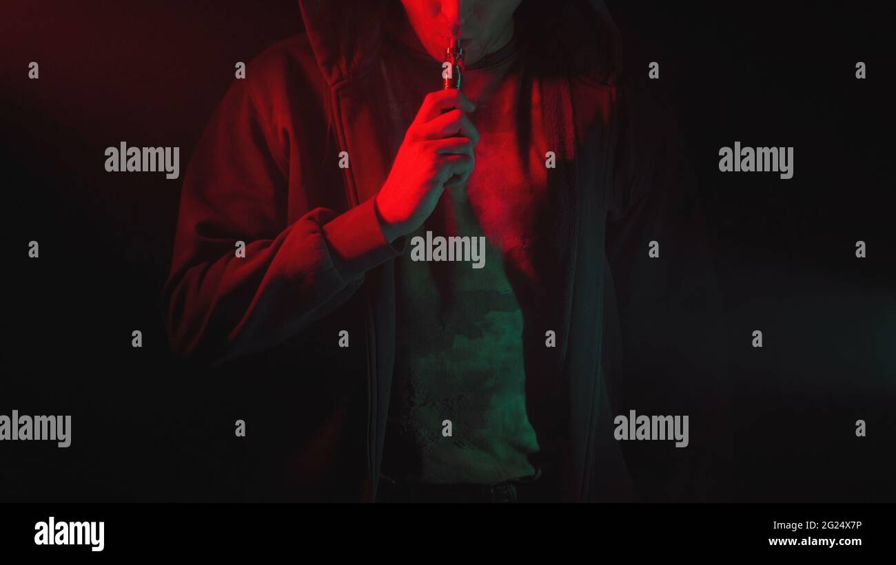 Photo of man with vape in red and green smoke Stock Photo - Alamy