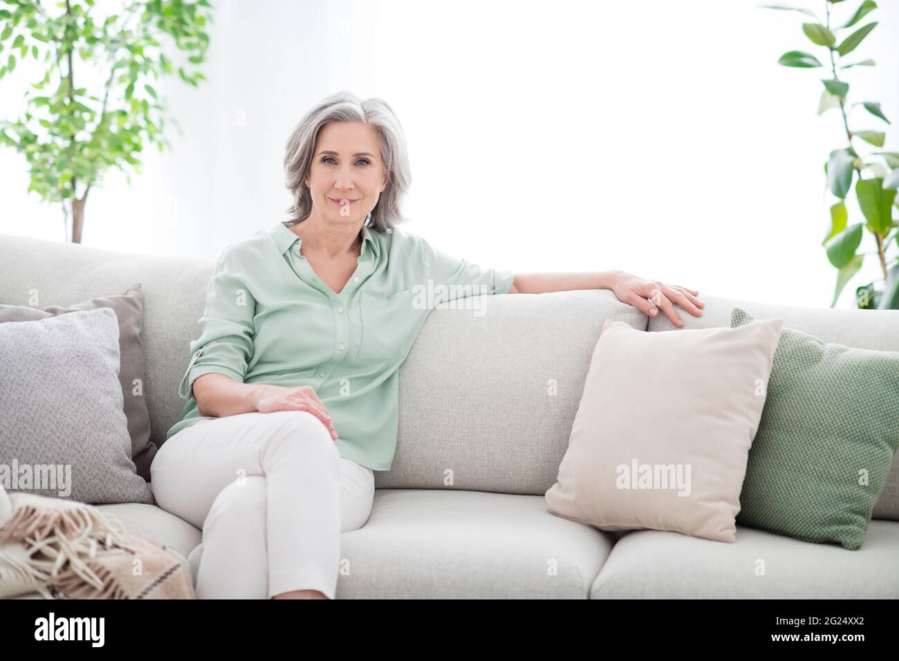 Photo of calm peaceful pretty old woman sit sofa good mood wekend wear ...