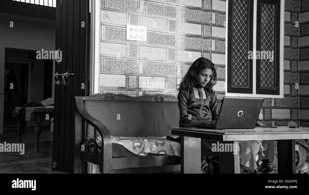 Portrait of a smiling young Indian girl holding laptop computer ...