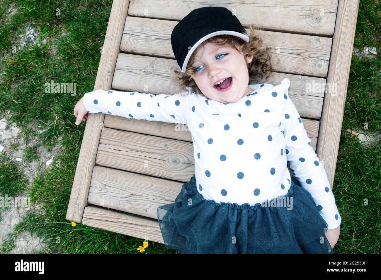 Overhead view of a happy girl lying on a wooden boardwalk Stock Photo ...