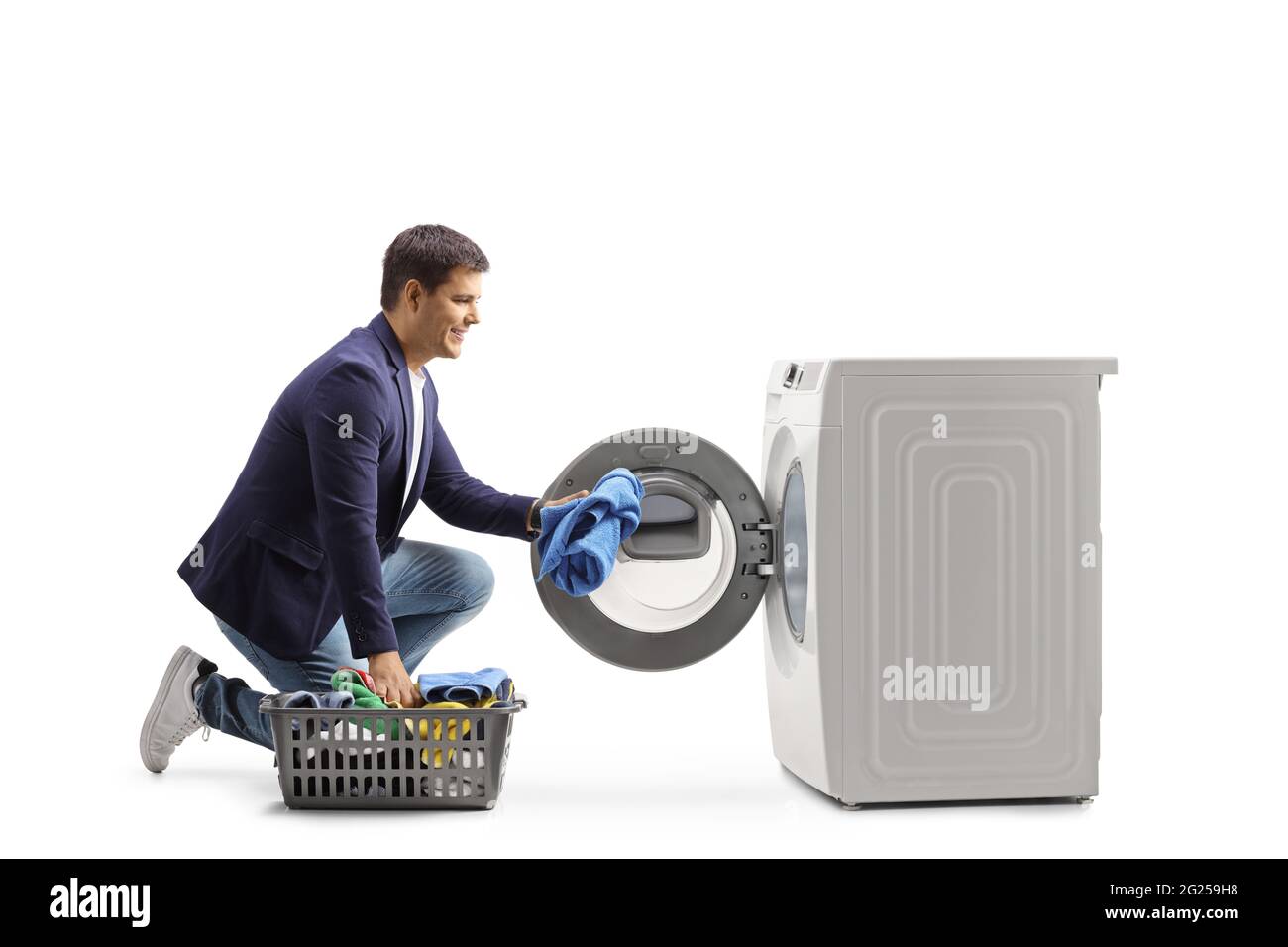 Young man loading a washing machine isolated on white background Stock ...