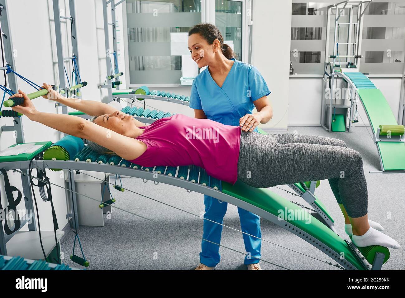 Physiotherapist assists a woman patient during spine and back ...