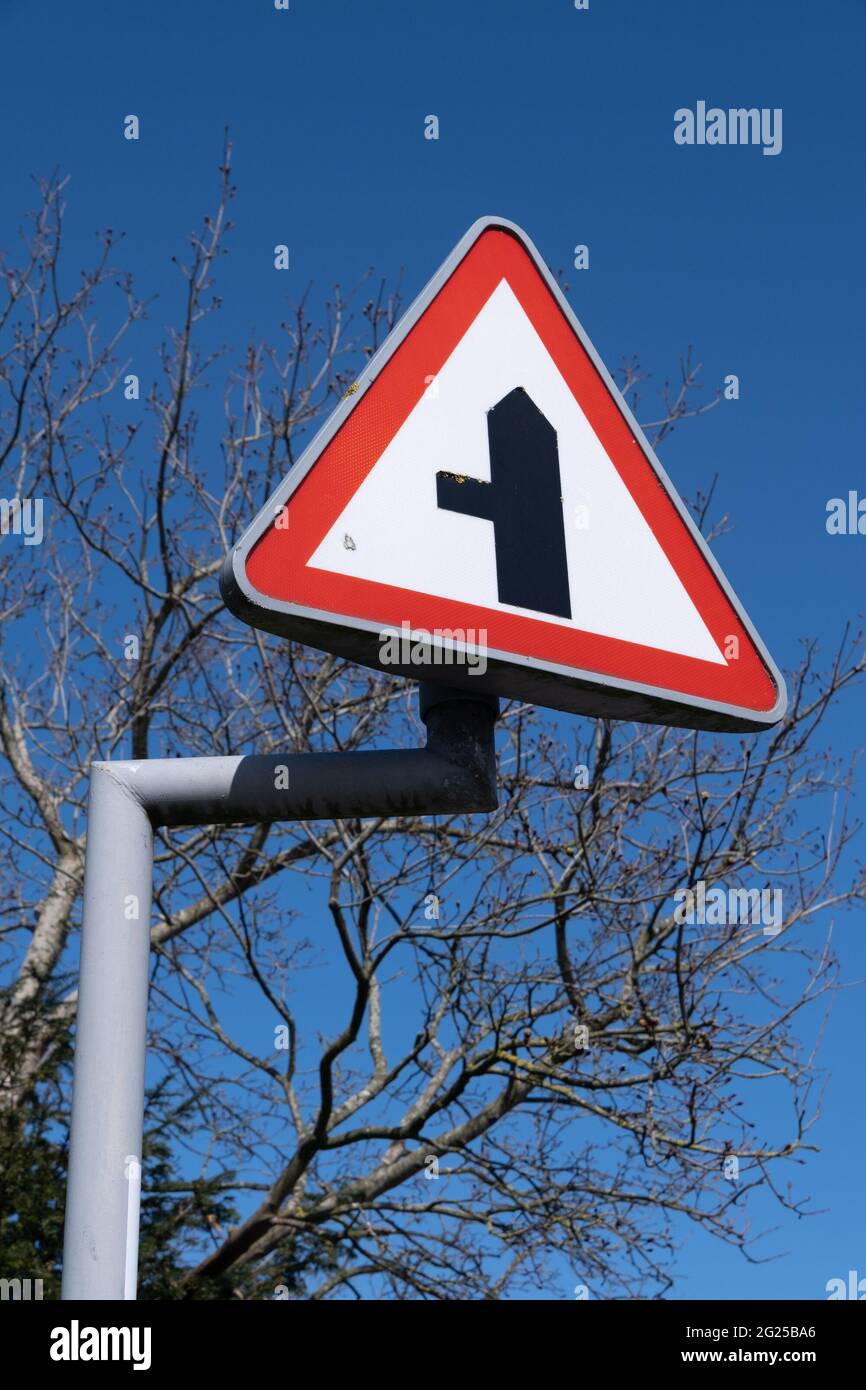 Red triangular sign warning of road on left in Saughall Massie Wirral ...