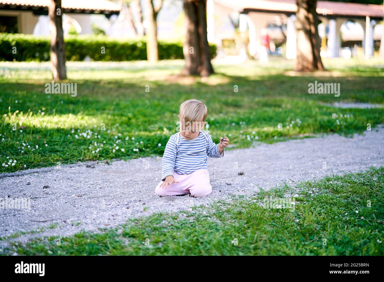 Kid kneeling in the grass hi-res stock photography and images - Alamy
