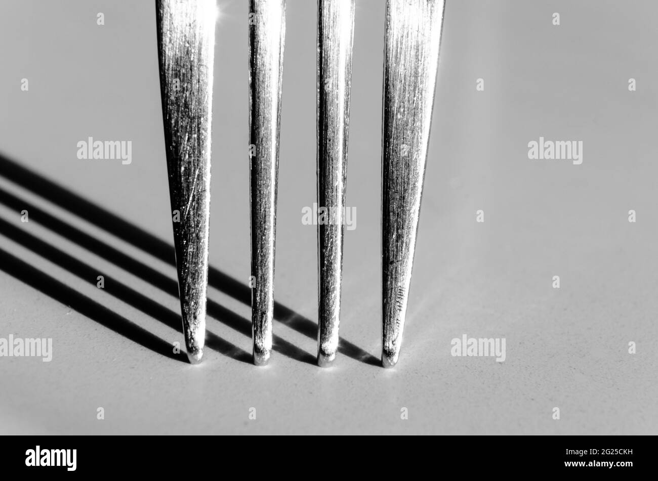 Grayscale shot of a fork on a surface with a sharp shadow Stock Photo ...