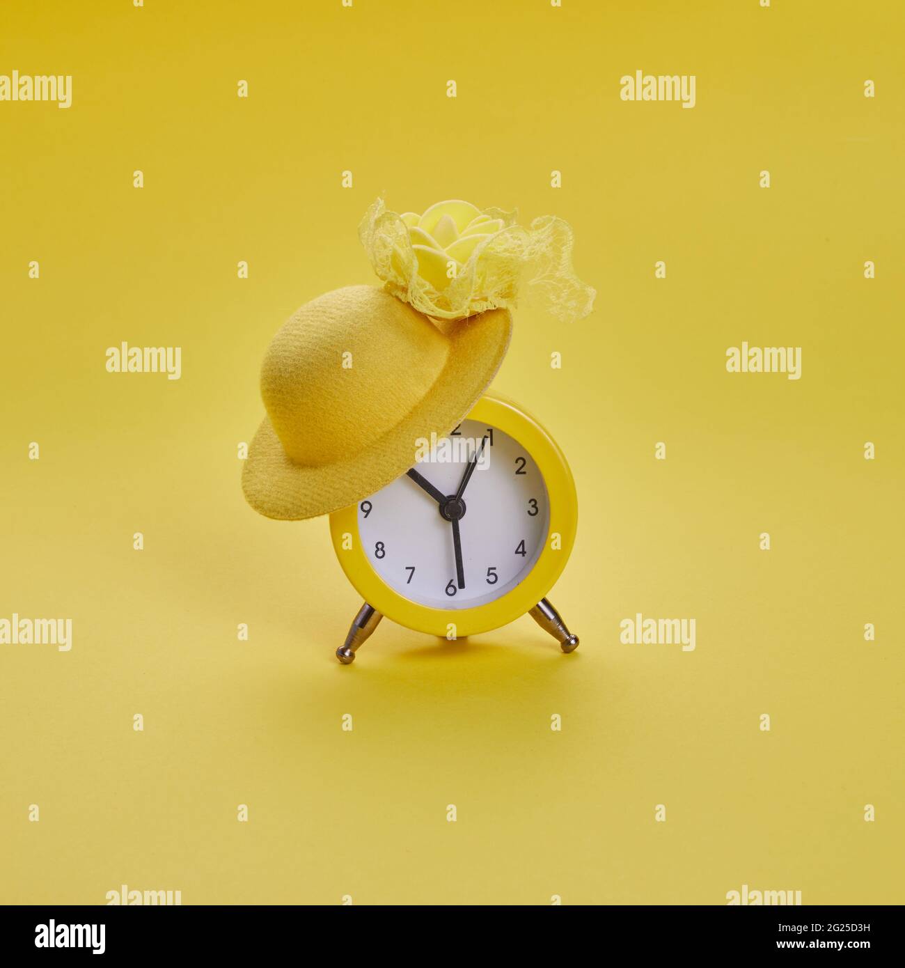 Alarm clock wearing heat on yellow background. Summer time concept ...