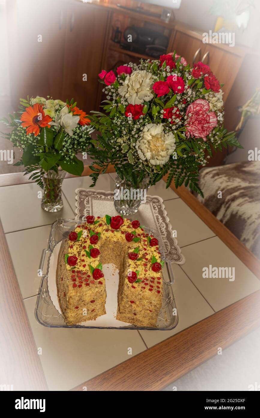 Big sweet color gateau with color fresh flowers in interior in birthday ...