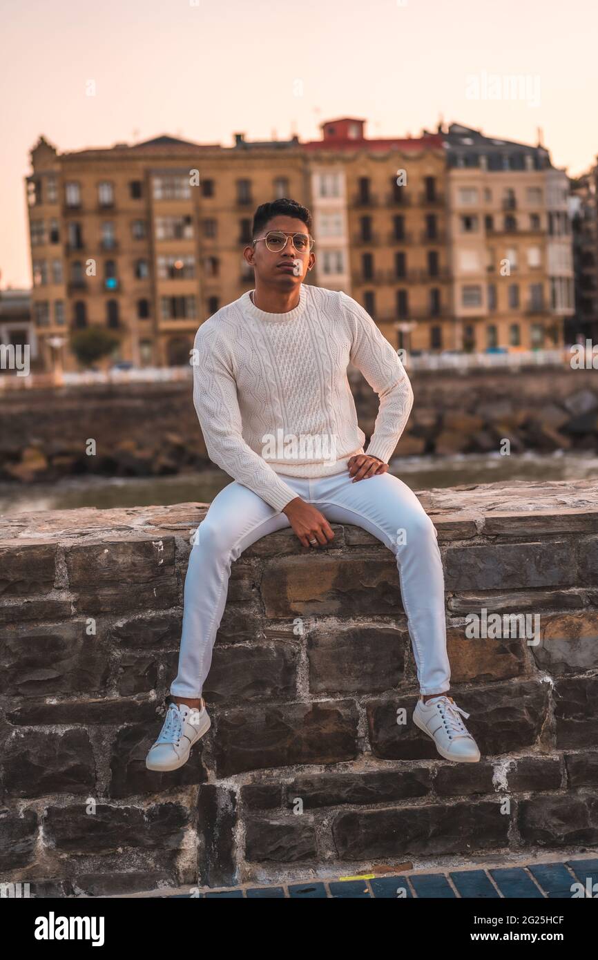 Handsome Hispanic guy sitting and enjoying summer vacation during the ...