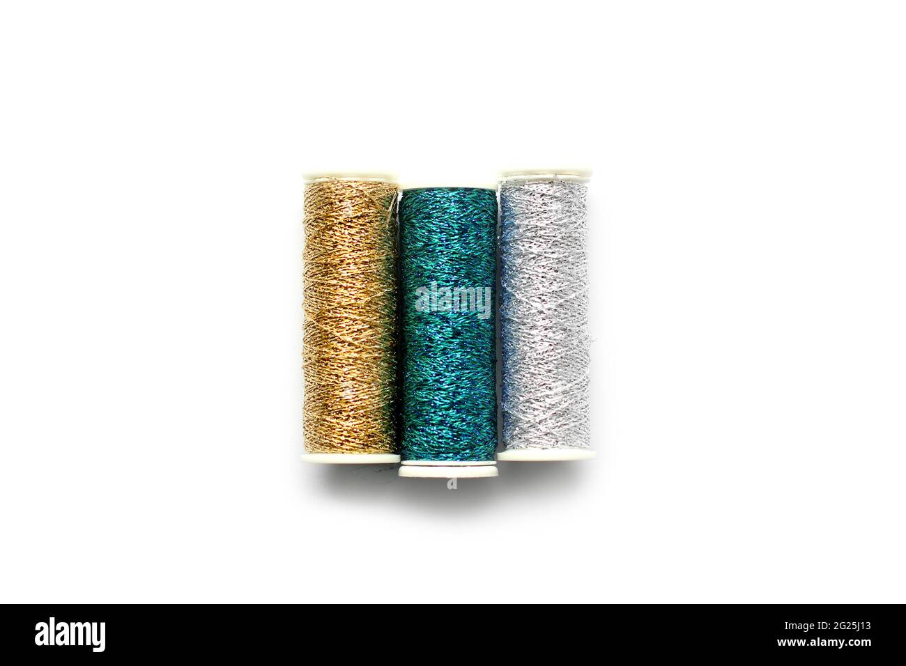 Sewing threads on a white background. Bright shiny threads. Gold and ...