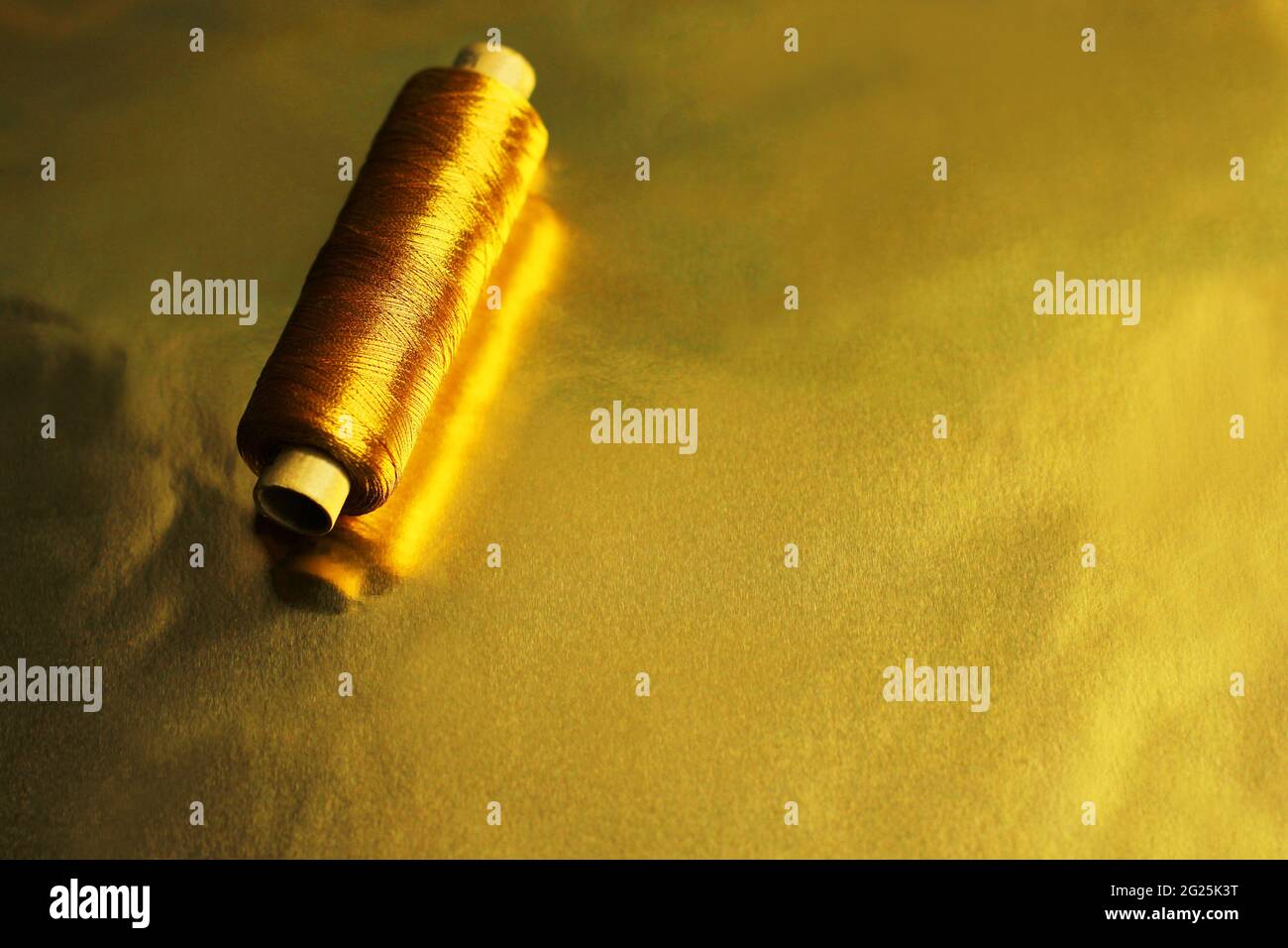 Sewing gold threads on a gold background. Bright shiny threads ...