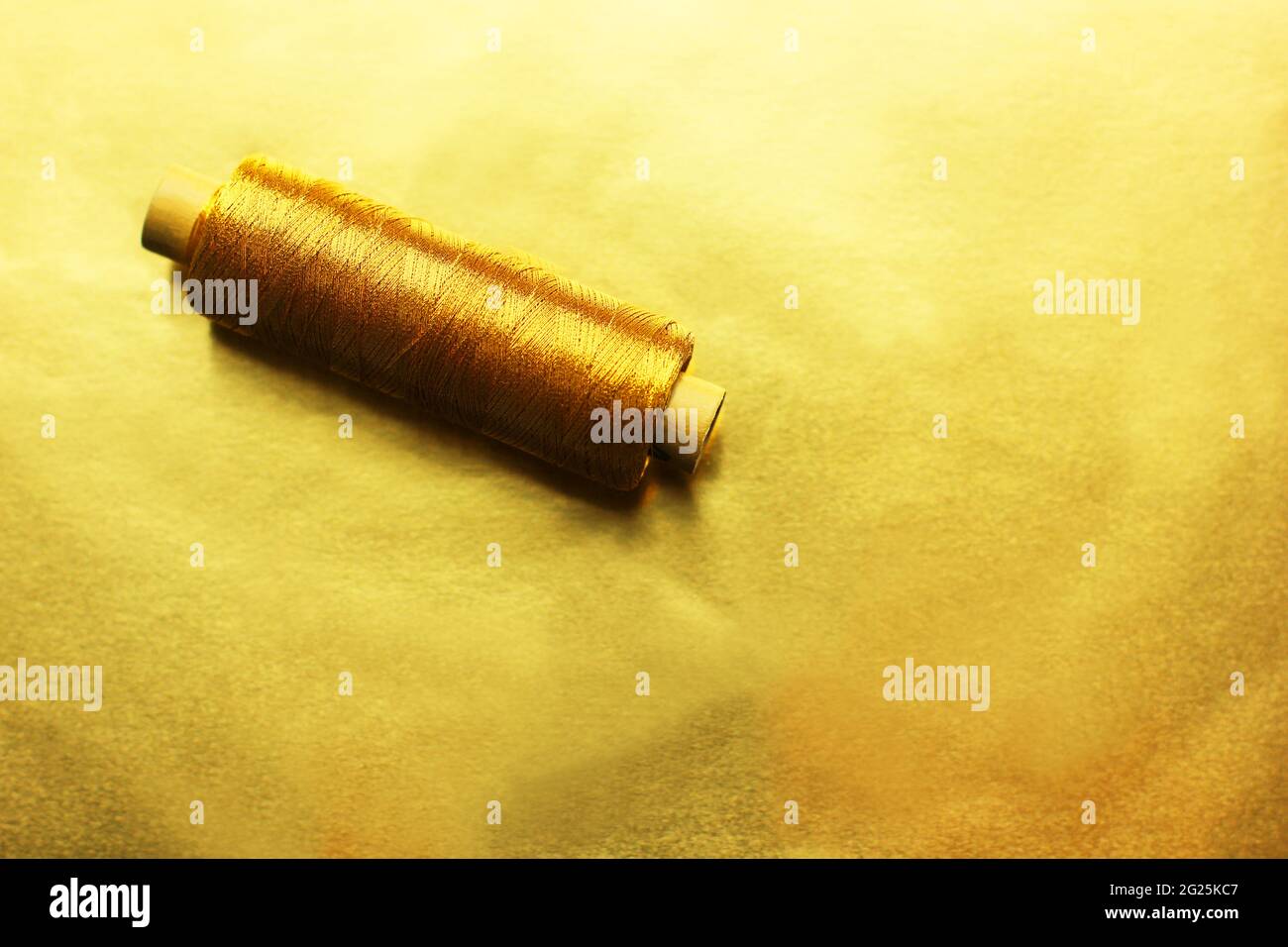 Sewing gold threads on a gold background. Bright shiny threads ...