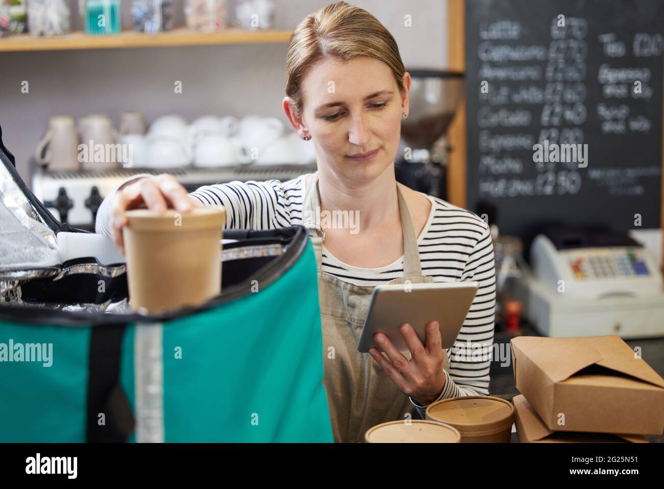 Female Restaurant Worker With Digital Tablet Packing Insulated Bag For ...