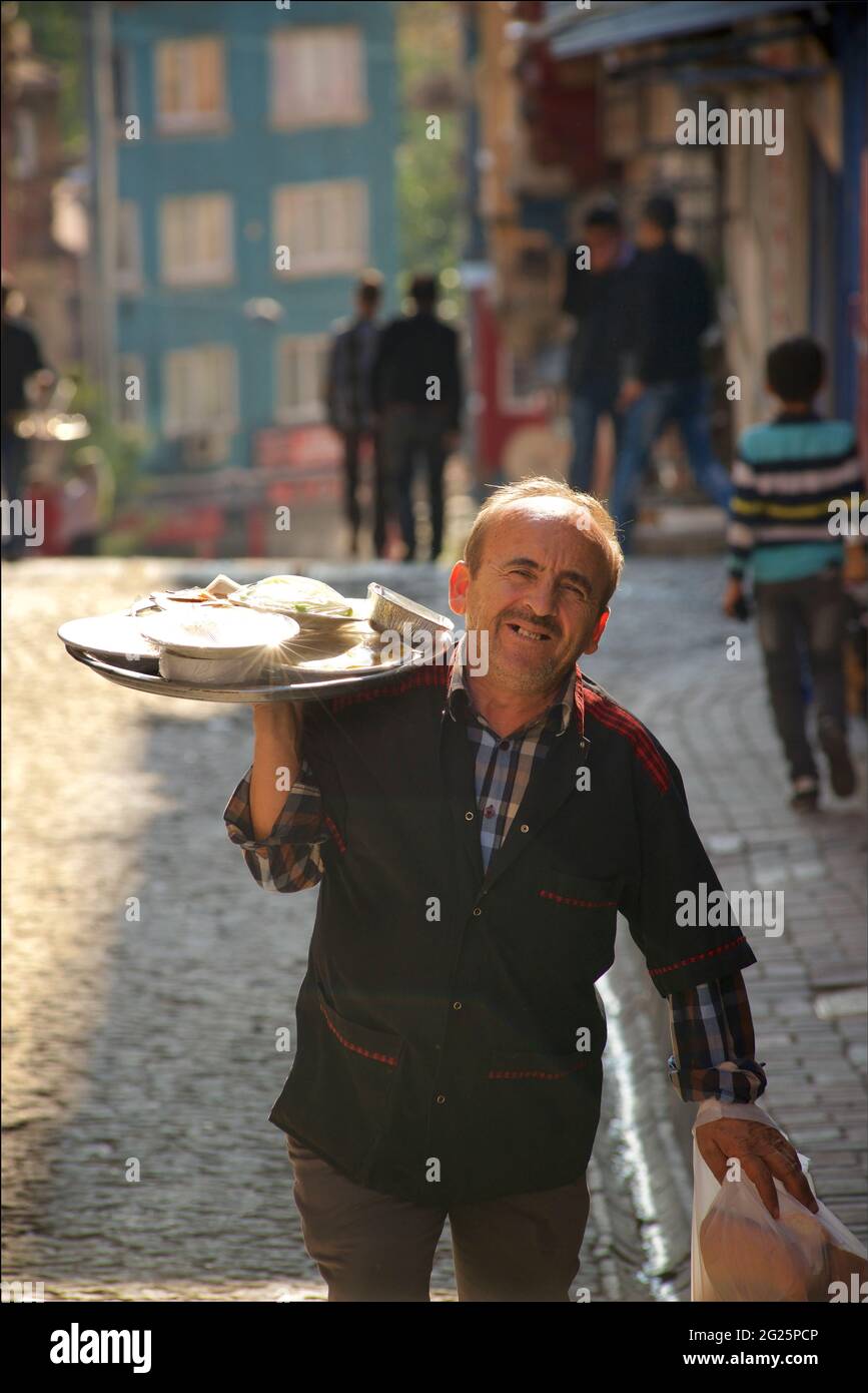 Turkish restaurant waiter with a tray of food delivering to a diner in ...
