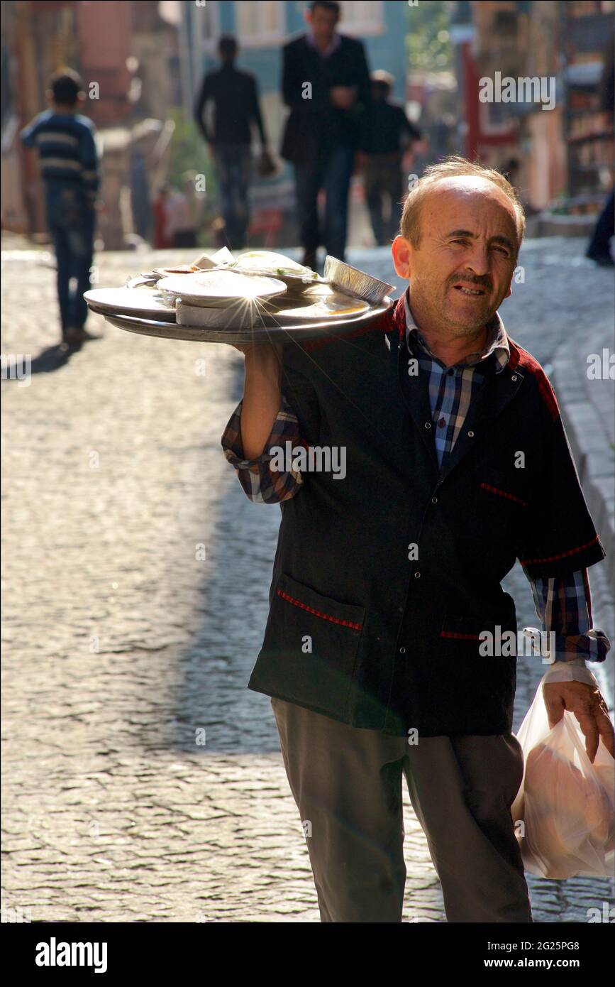 Turkish restaurant waiter with a tray of food delivering to a diner in ...