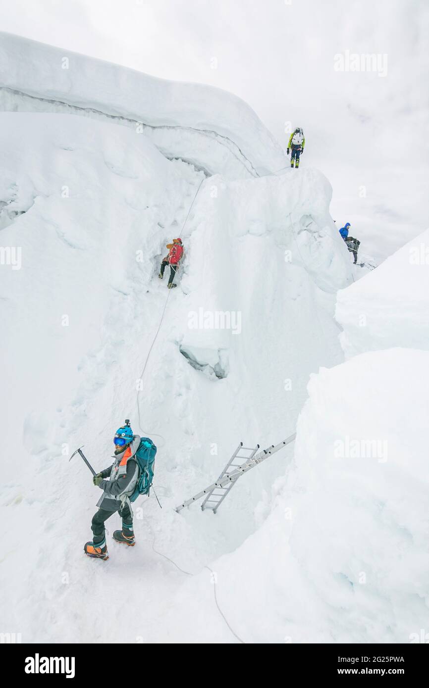 Rope team navigating a big crevasse in the Himalayas Stock Photo - Alamy