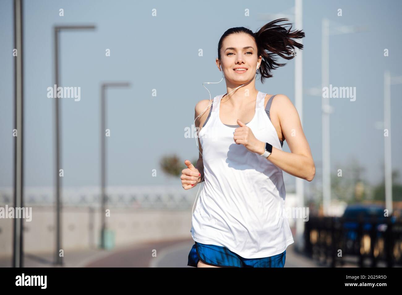 Ecstatic athletic woman running on the track outdoors. Blurred ...