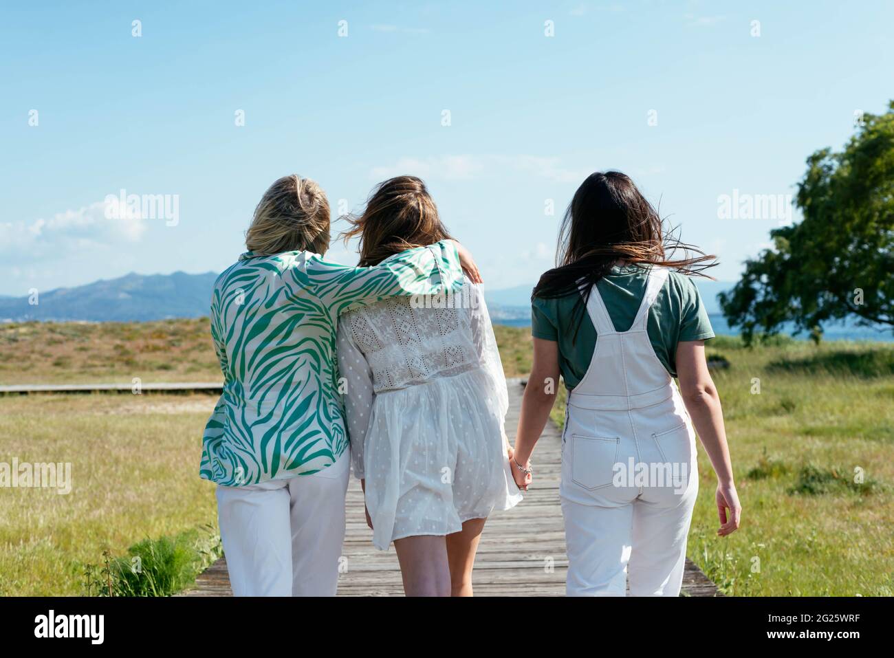 Three anonymous girls walking and looking happy Stock Photo - Alamy
