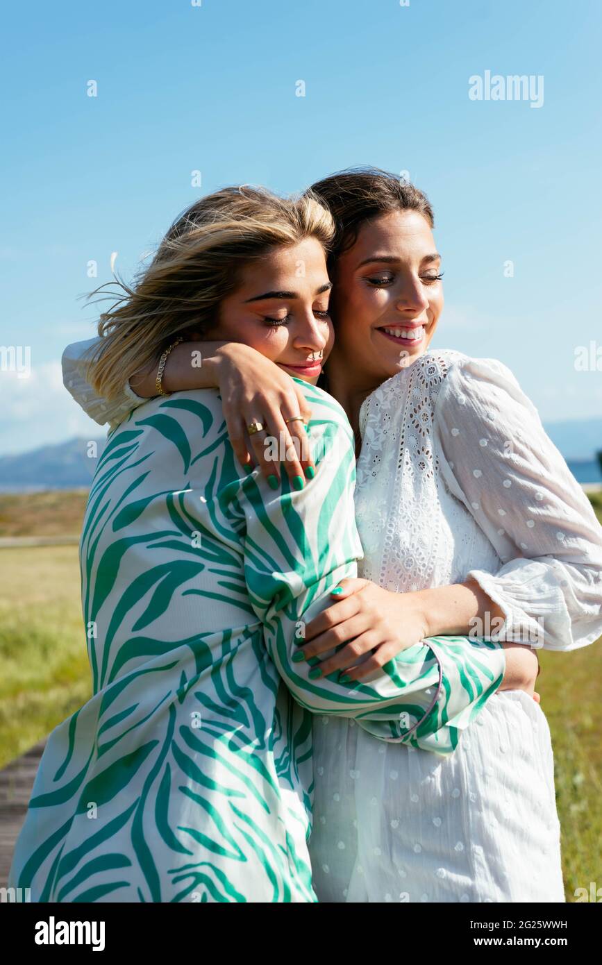 Smiling girls hugging each other Stock Photo - Alamy