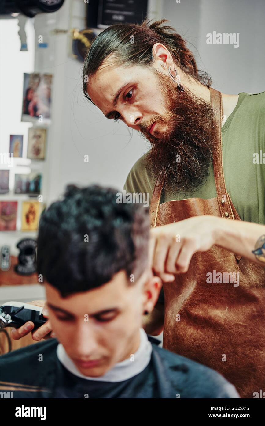 A barber is shaving off the hair of a boy Stock Photo - Alamy