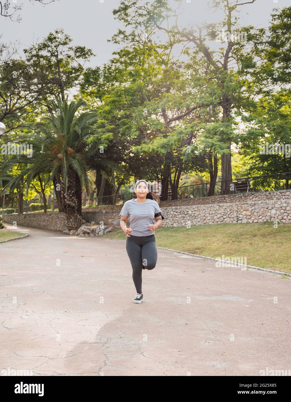 young girl running down a park path Stock Photo - Alamy