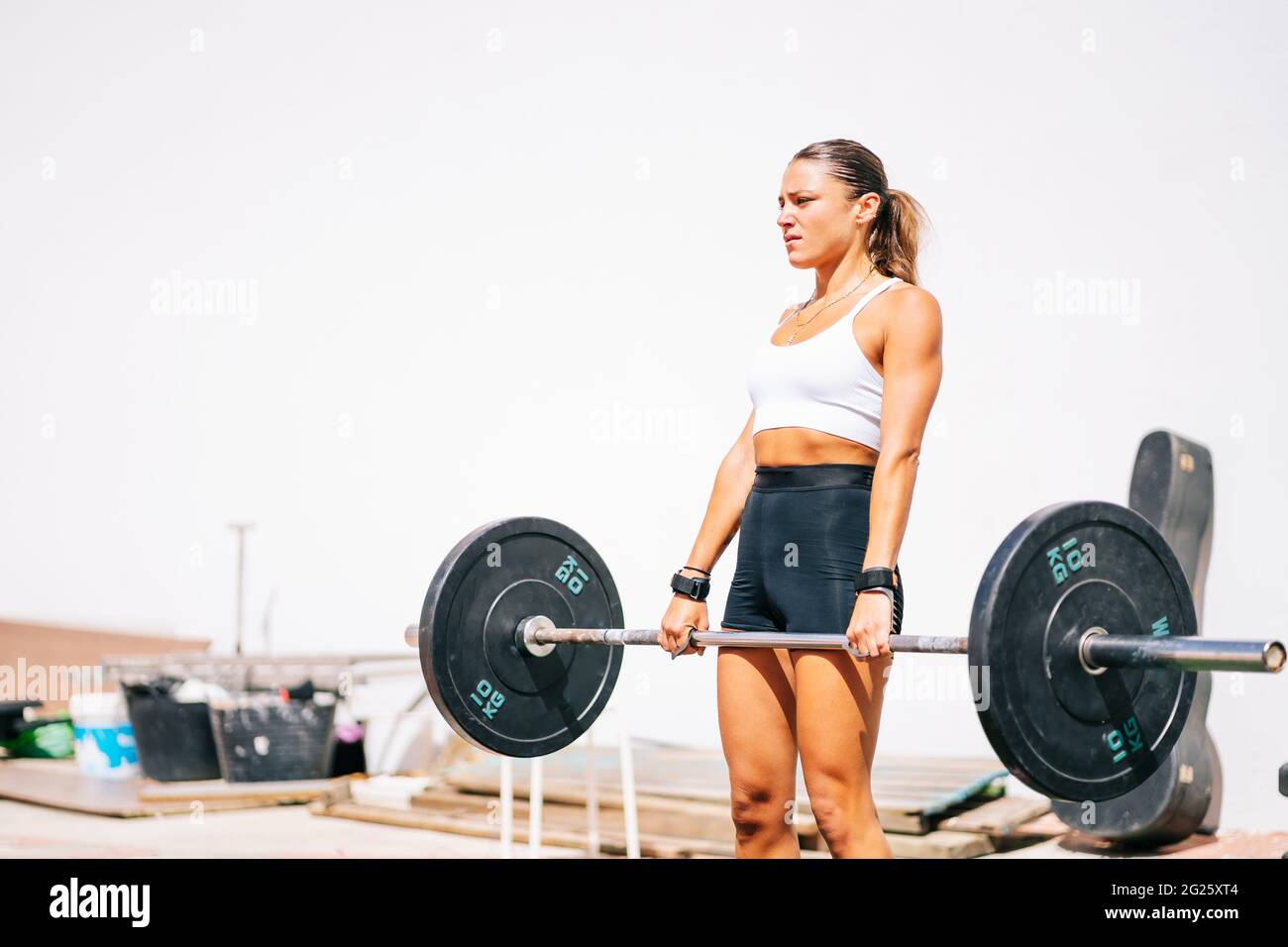 A strong woman performing deadlift with dumbbells outdoors Stock Photo ...