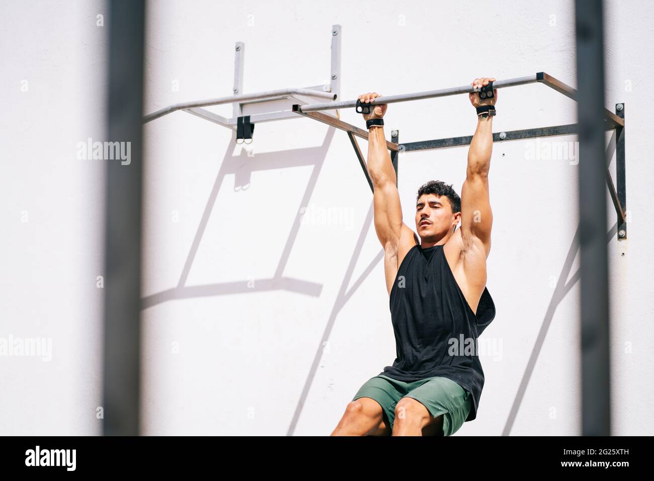Strong man performing pull-up exercise outdoors Stock Photo - Alamy