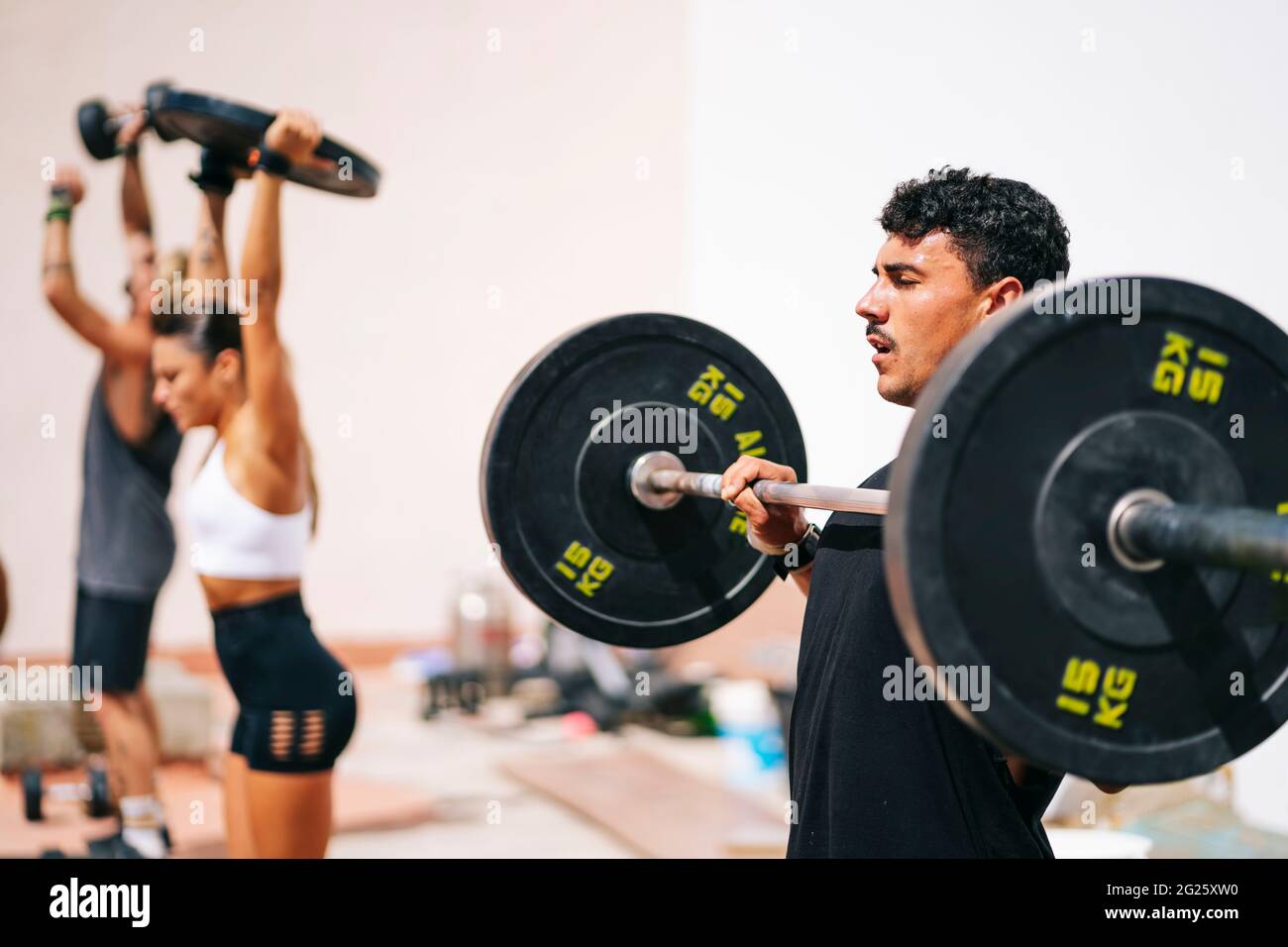 A group of sporty friends perform different exercise routines outdoors ...
