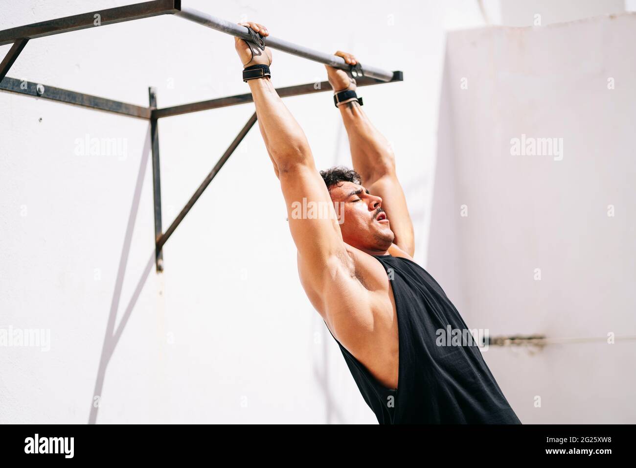 Strong man performing pull-up exercise outdoors Stock Photo - Alamy