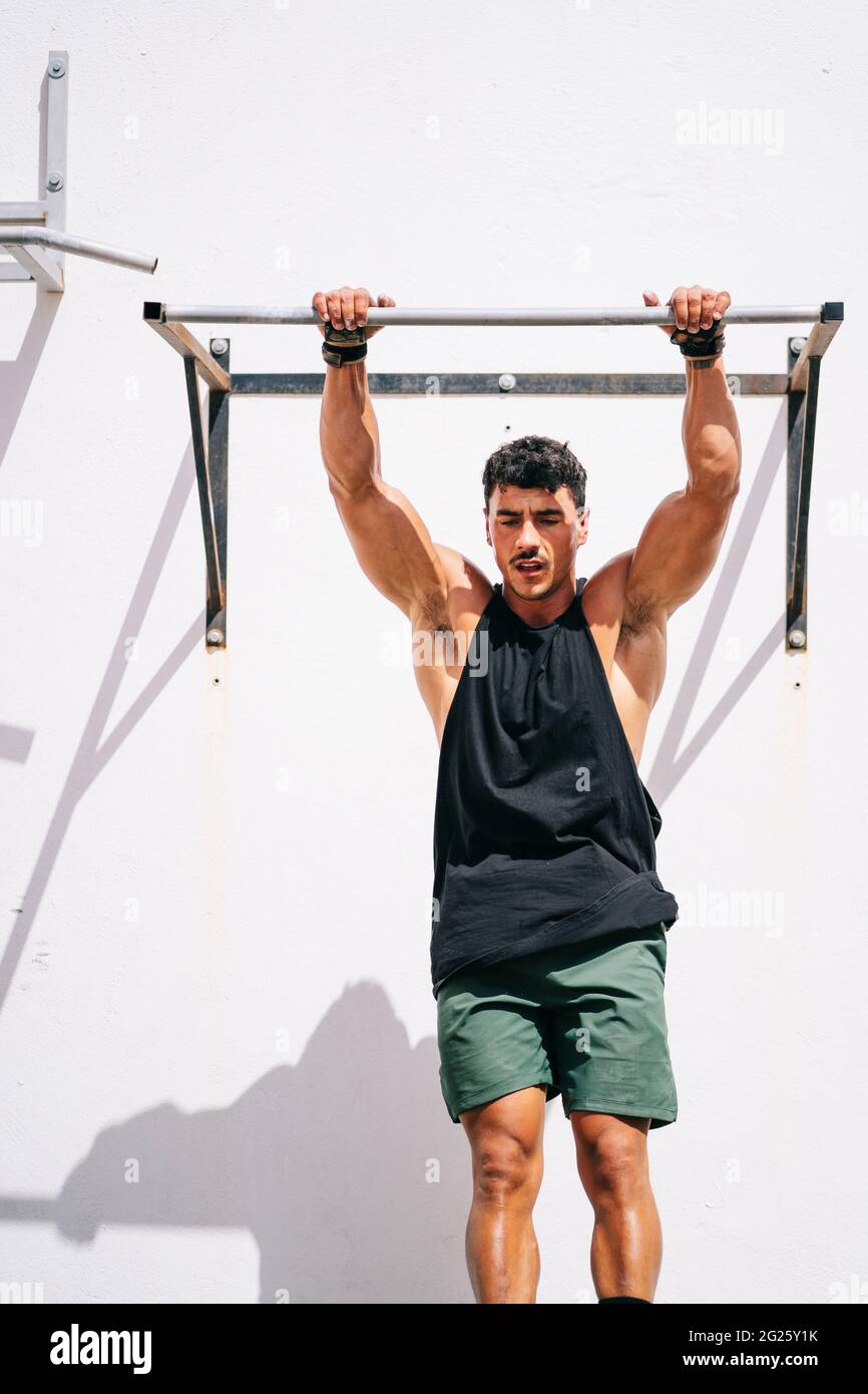 Strong man performing pull-up exercise outdoors Stock Photo - Alamy