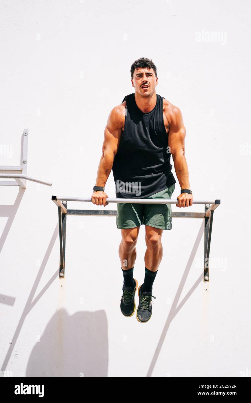 Strong man performing pull-up exercise outdoors Stock Photo - Alamy
