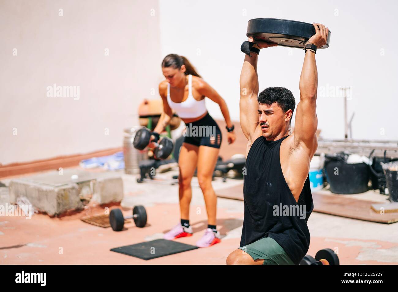 A group of sporty friends perform different exercise routines outdoors ...