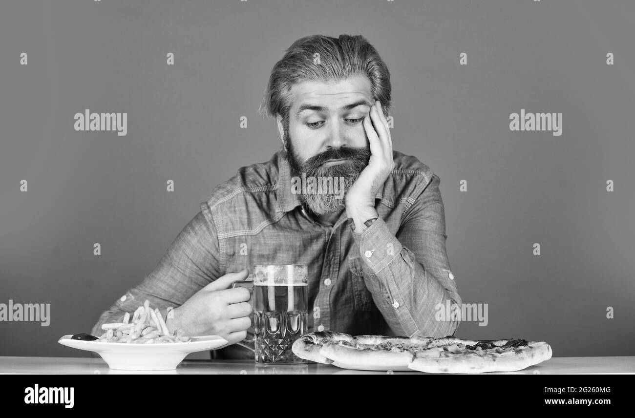 Bad appetite. Bored and sad. Beer and food. Dinner at pub. Hungry man ...