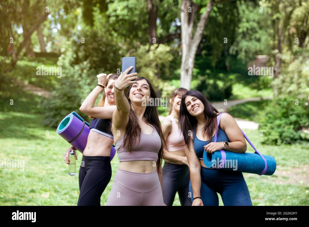 Group of sporty girls taking a photo with a smartphone outdoors ...